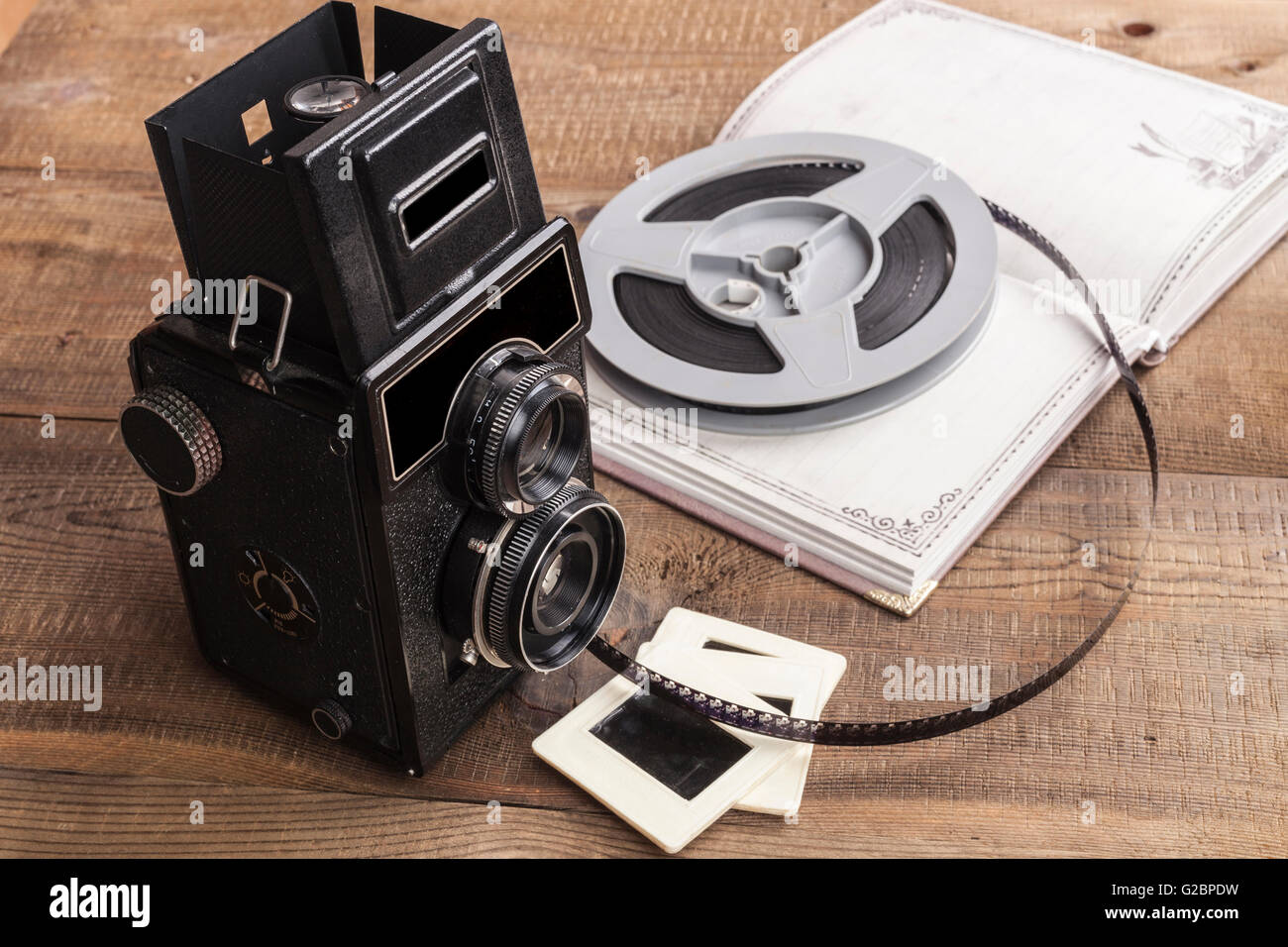 Old Camera With Film Roll and Notebook on Wood Table Stock Photo - Alamy