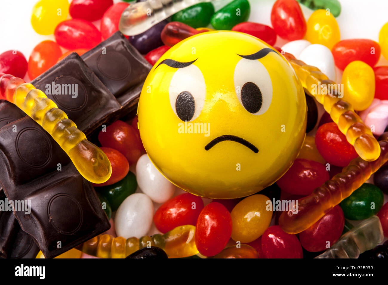 Sad emoticon and a lot of sweets Stock Photo - Alamy