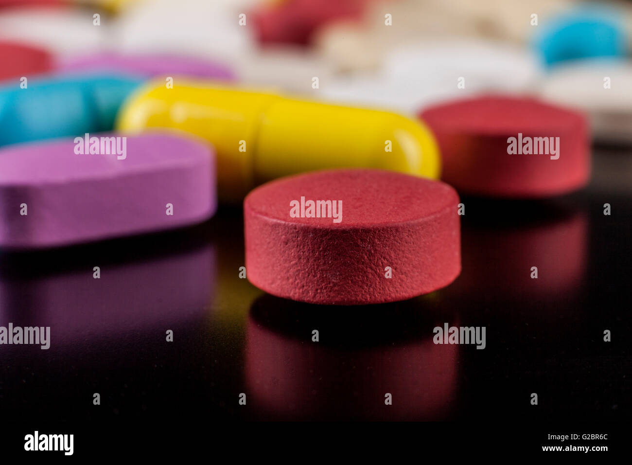 Colored Pills Closeup on Black Background With Reflection Stock Photo ...