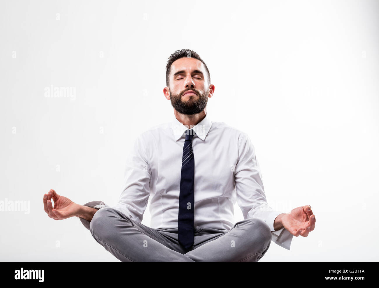 relaxed business man in meditation pose on white background Stock Photo ...