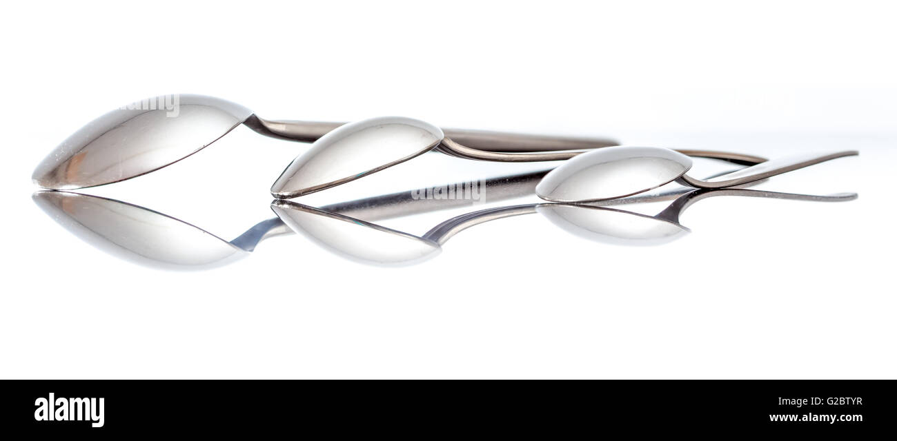 this metal spoons on an reflection of an tile Stock Photo - Alamy