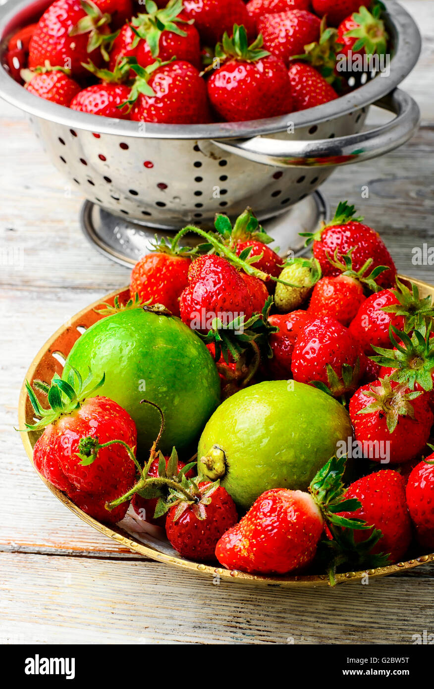 Harvest rustic strawberry and lime fruit on light background Stock ...