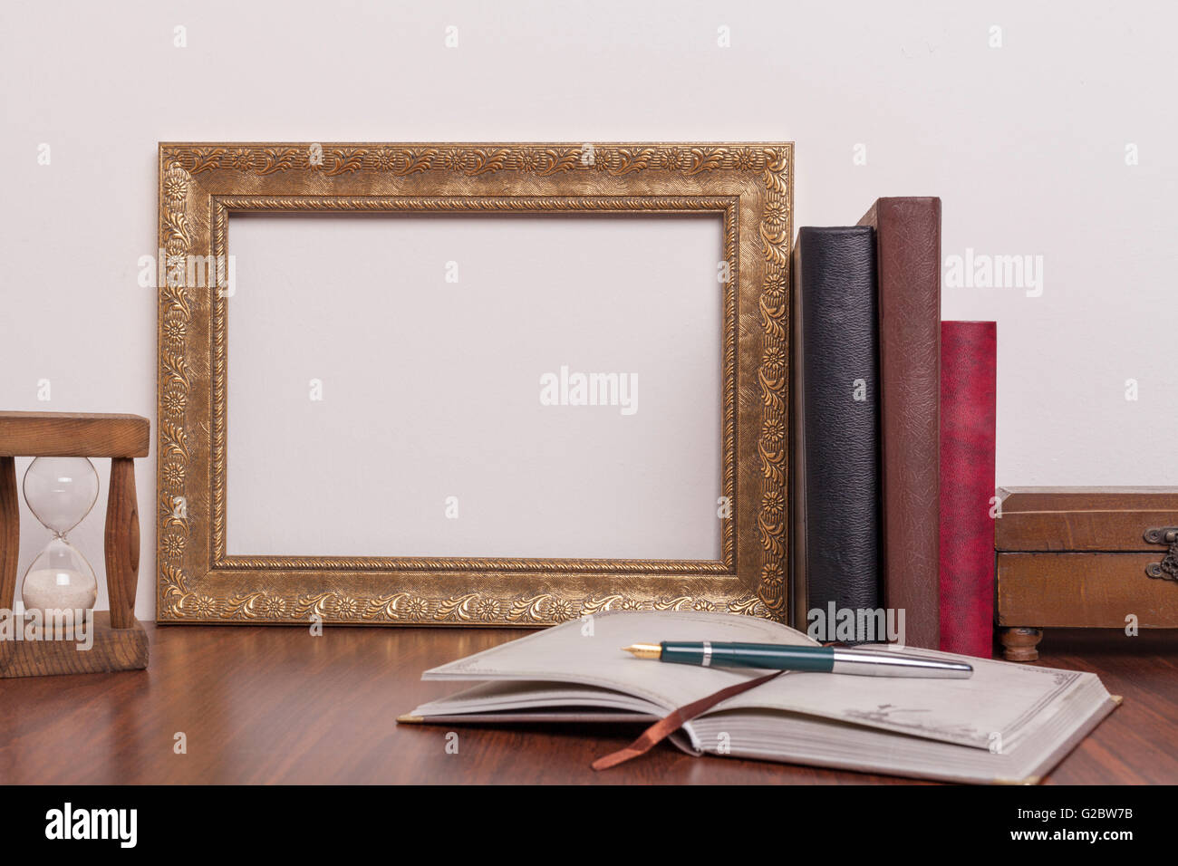 Landscape golden frame with books and horglass on wood table Stock ...