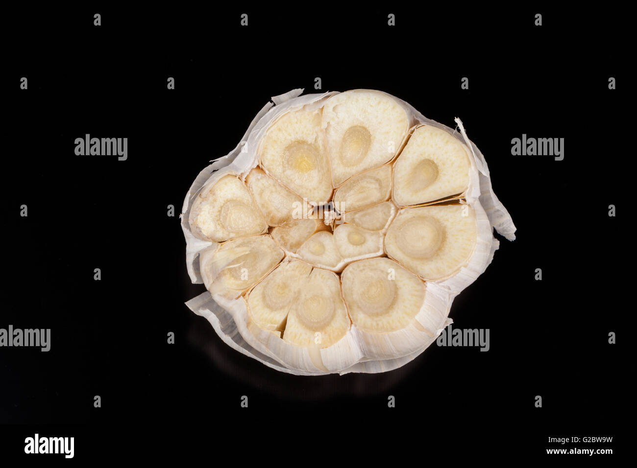 Cut garlic isolated on black background Stock Photo - Alamy