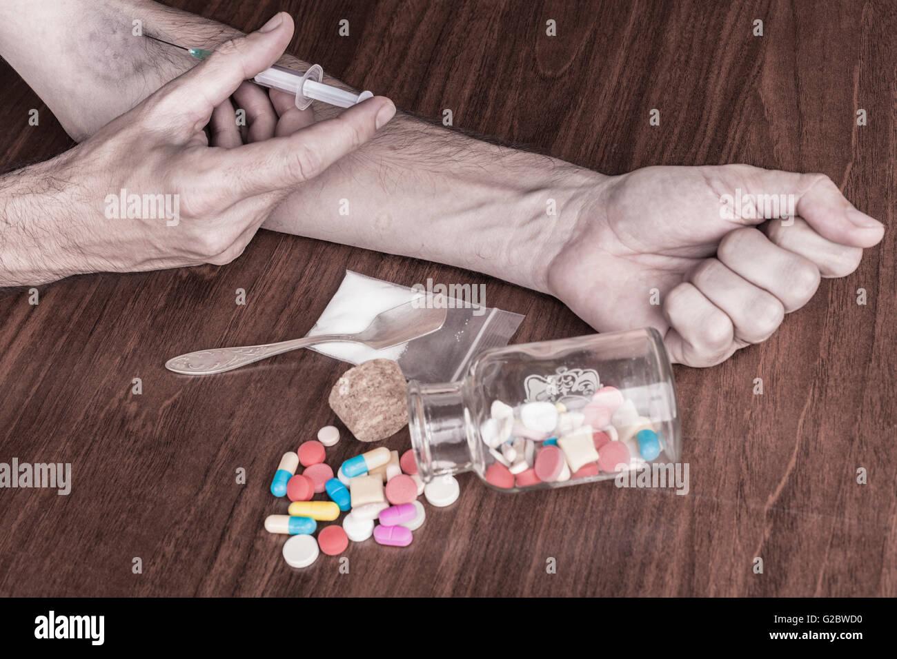 Bruised hand with needle and pills on the table Stock Photo - Alamy