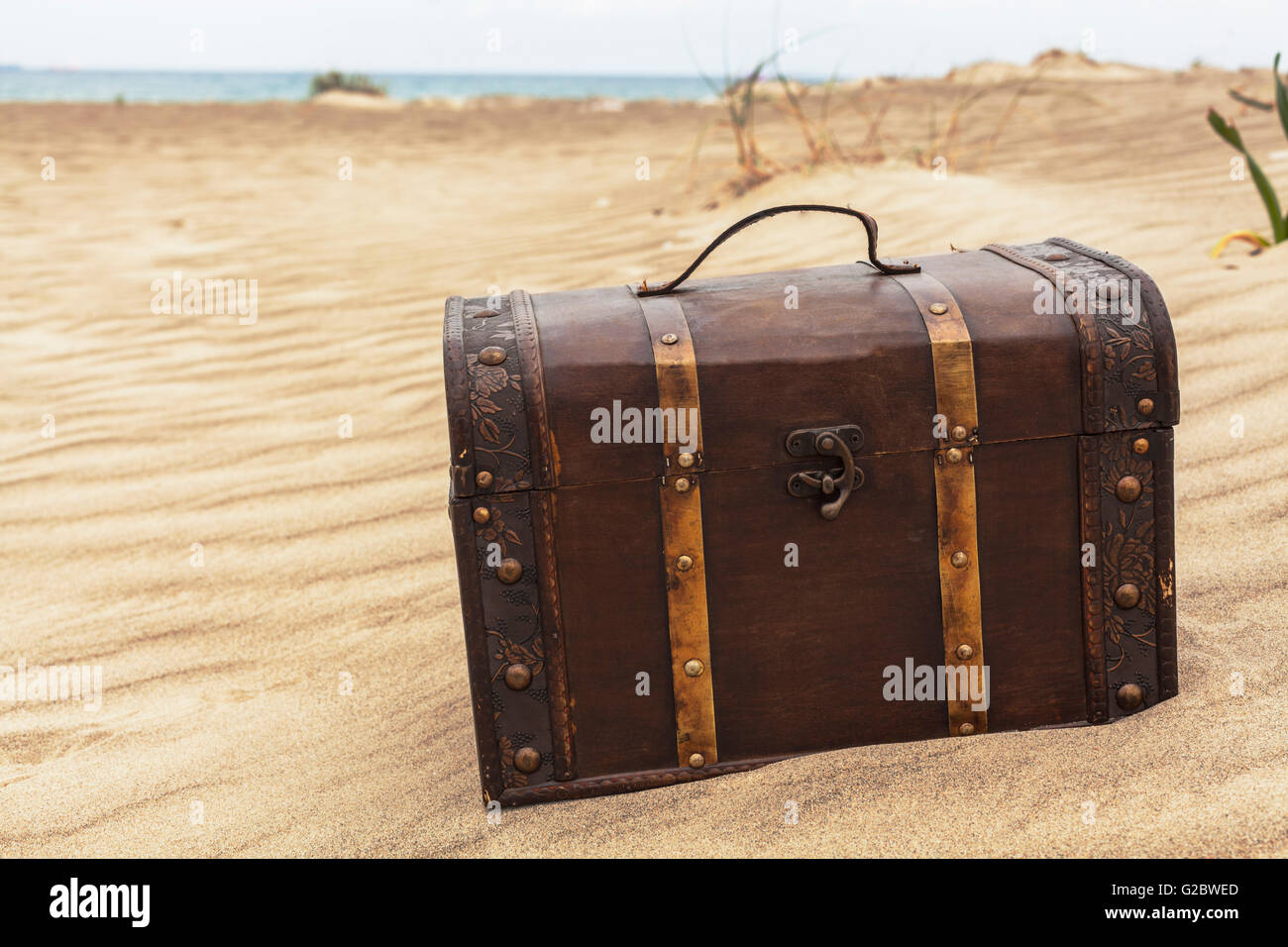 Treasure chest in sand dunes on a beach Stock Photo - Alamy