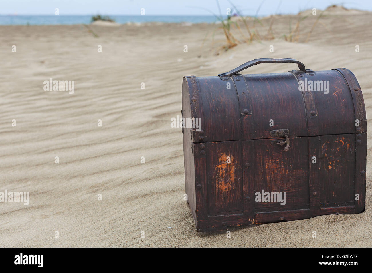 Treasure chest in sand dunes on a beach Stock Photo - Alamy