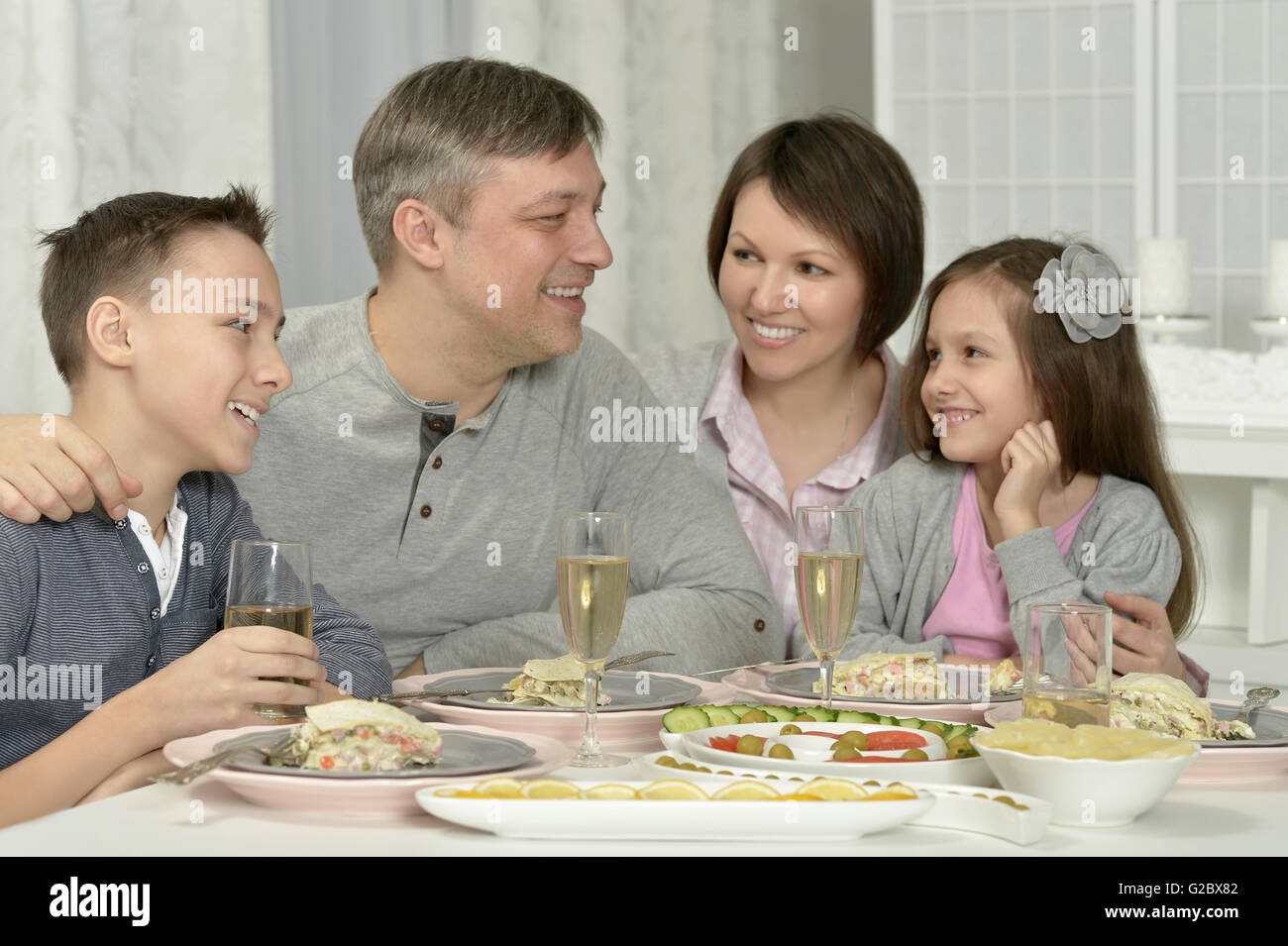 Happy family having dinner Stock Photo - Alamy