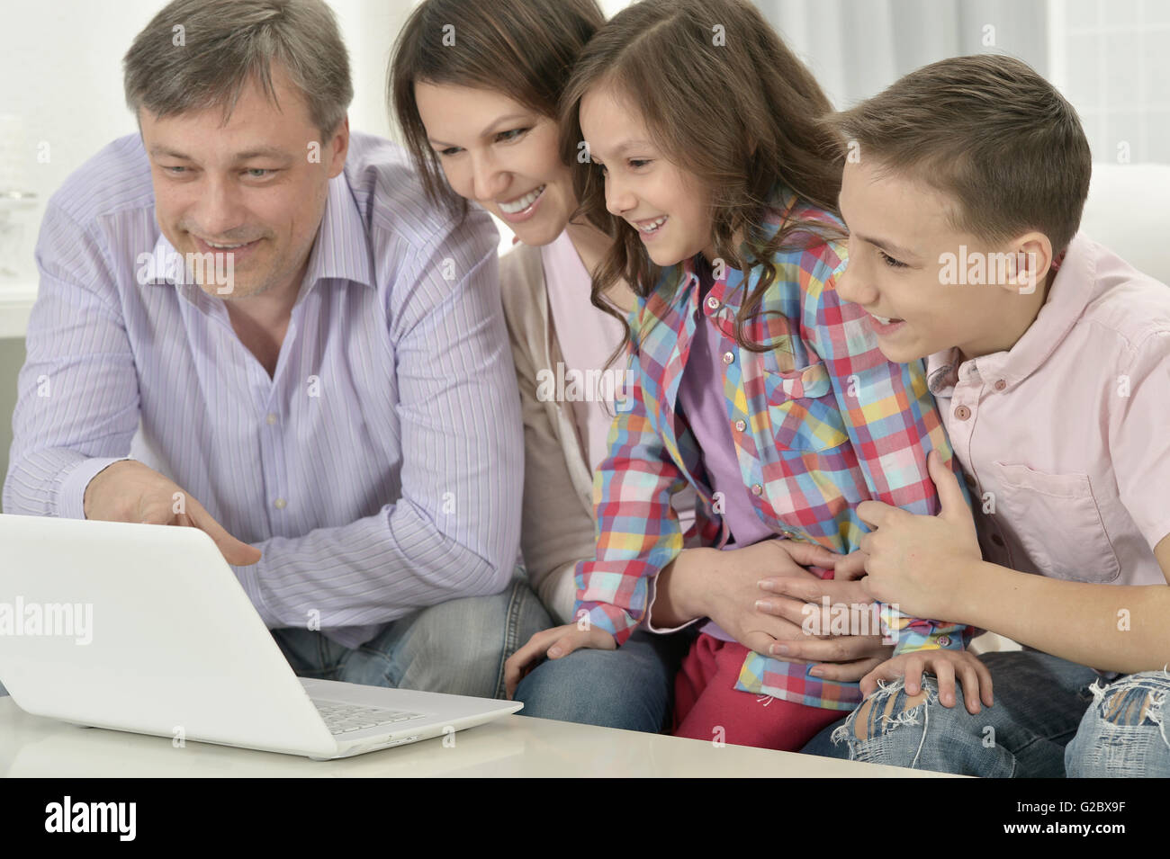 Happy family with laptop Stock Photo - Alamy