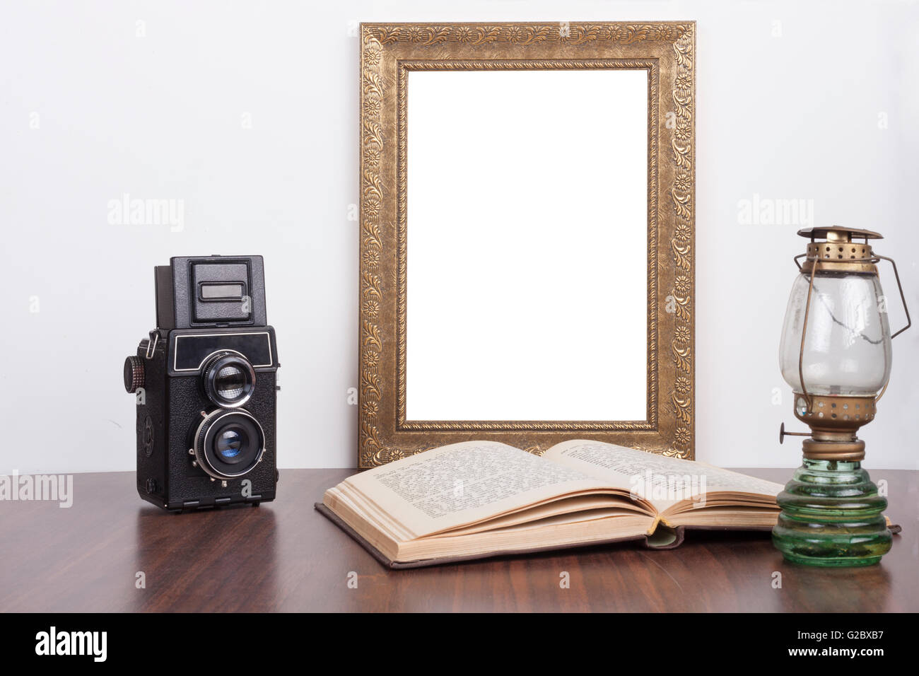 Old Gold frame with old camera and open book with lamp Stock Photo - Alamy