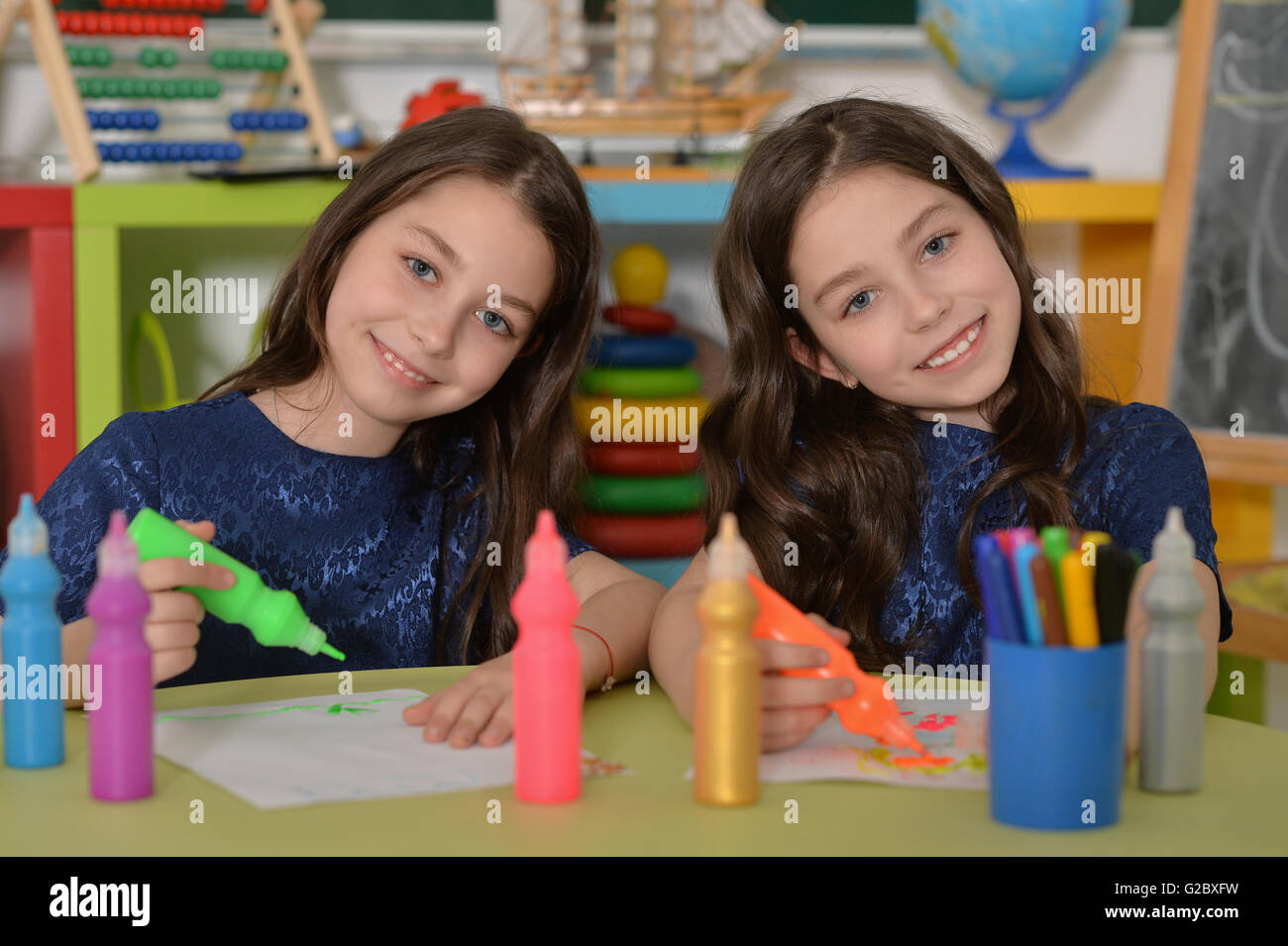 schoolgirls twins on lesson of art Stock Photo - Alamy