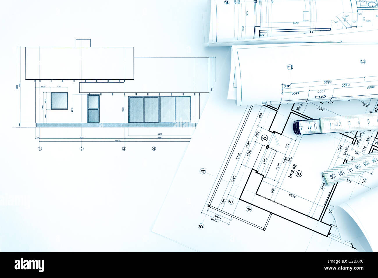 home plans and blueprint rolls with folding rule, architects workspace ...