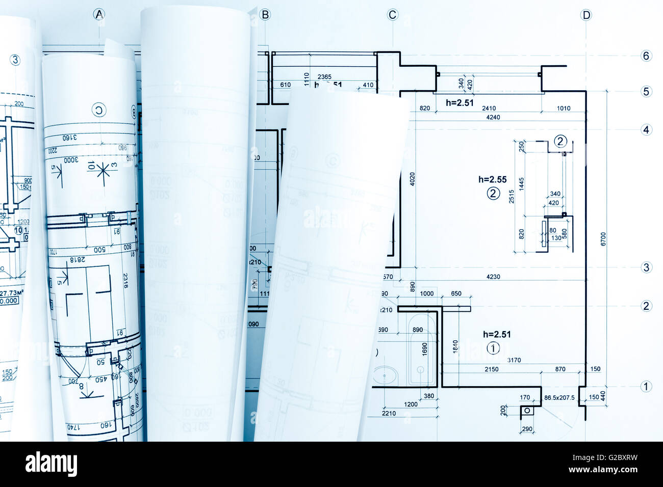 rolls of architectural blueprints and technical drawings on workspace ...