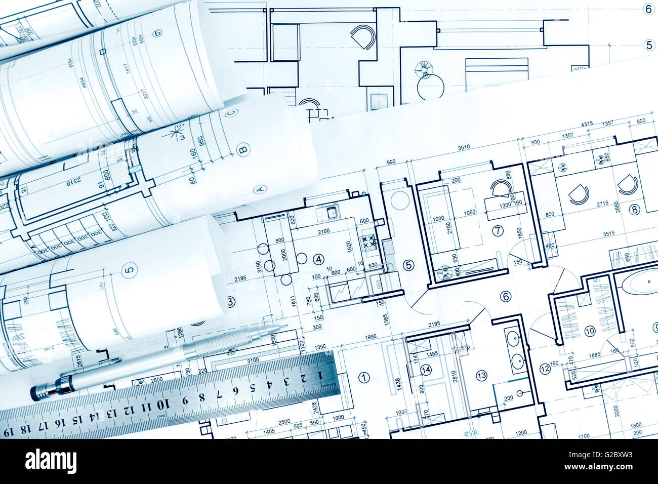 rolls of architectural blueprints and technical drawings with ruler and ...