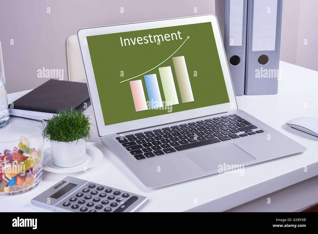 Computer with positive investment chart on desk Stock Photo - Alamy