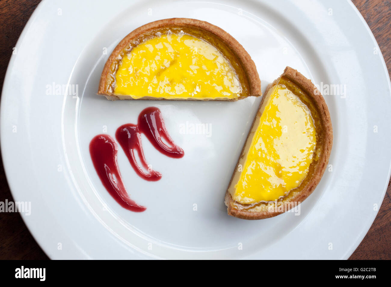 French tarte au citron (lemon tart) with raspberry coulis Stock Photo ...