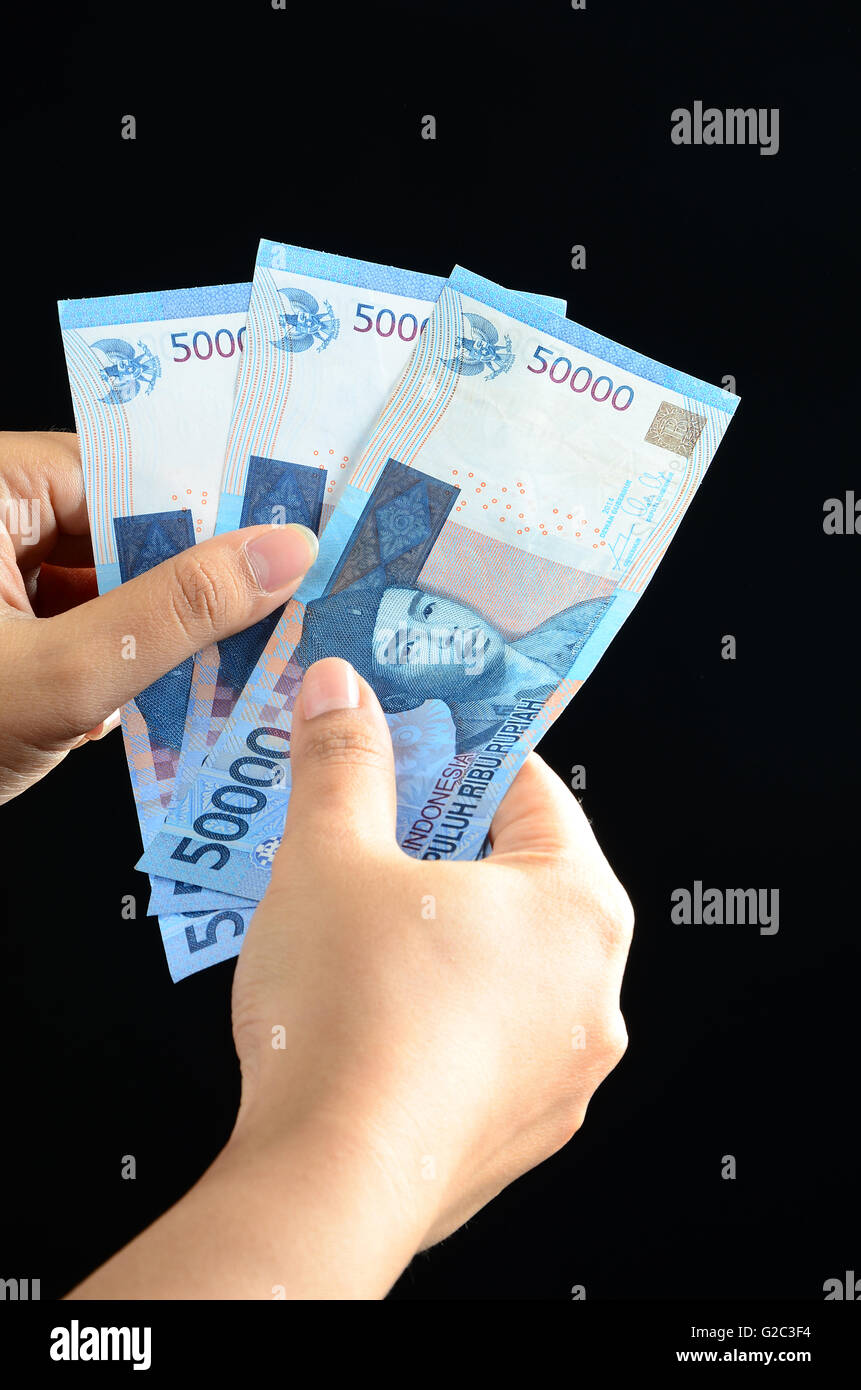 hand holding money, in rupiah, Indonesia currency Stock Photo - Alamy