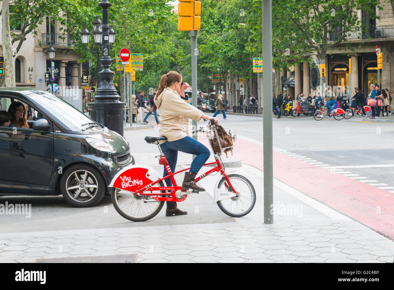 Spain Catalonia Barcelona young girl at lights on hire City bike ...