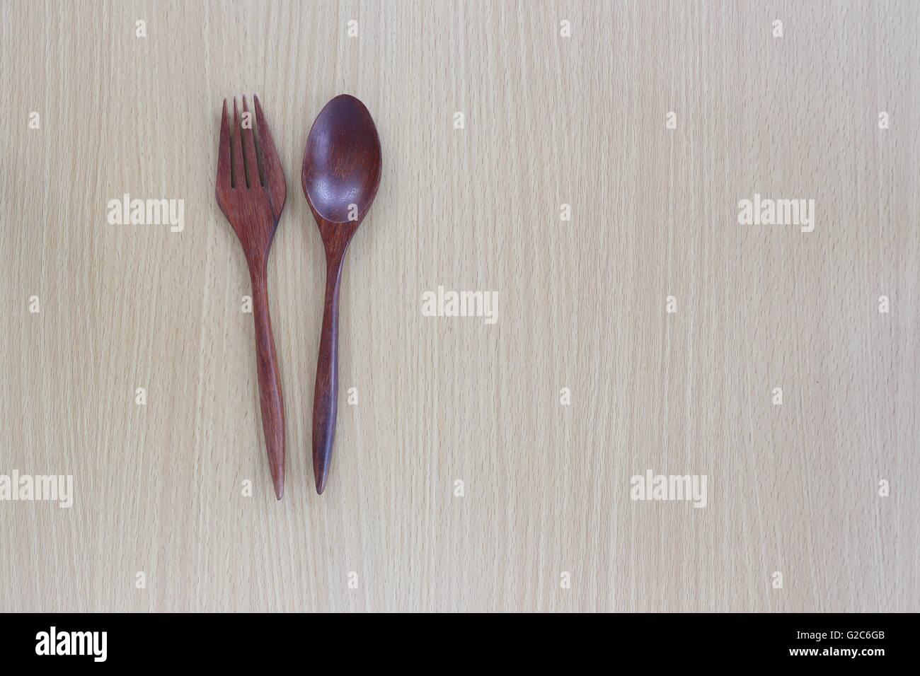 Wooden spoon and fork in top view on wood background for design concept ...