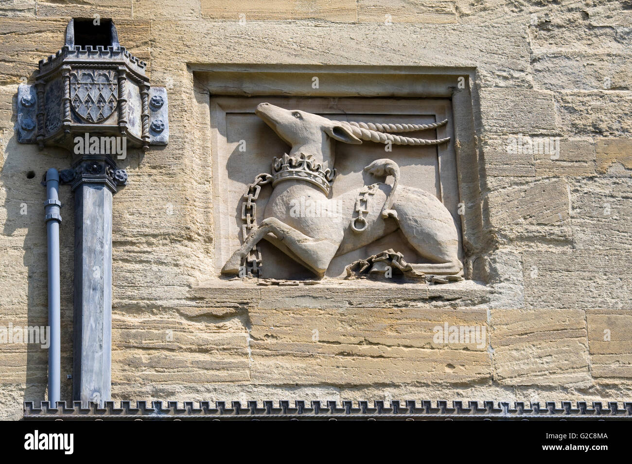Stone sculpture of a Antelope in chains beside a decorative drainpipe ...