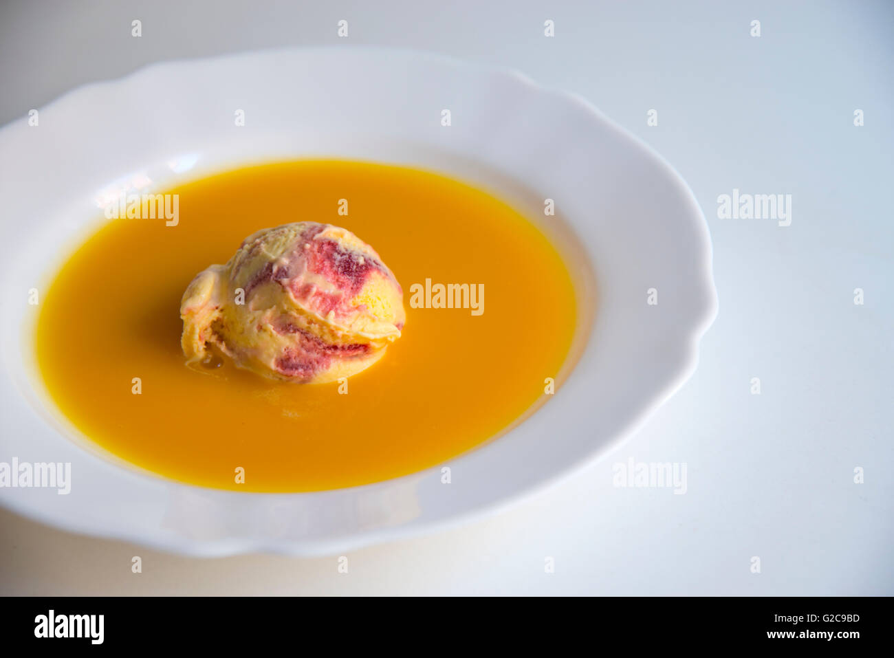 Mango and raspberry ice cream in mango juice Stock Photo - Alamy