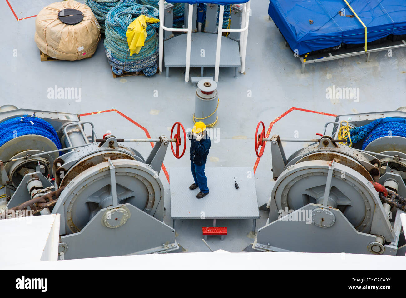 Deck hand prepares to lower the anchor of the Vision of the Seas cruise ...