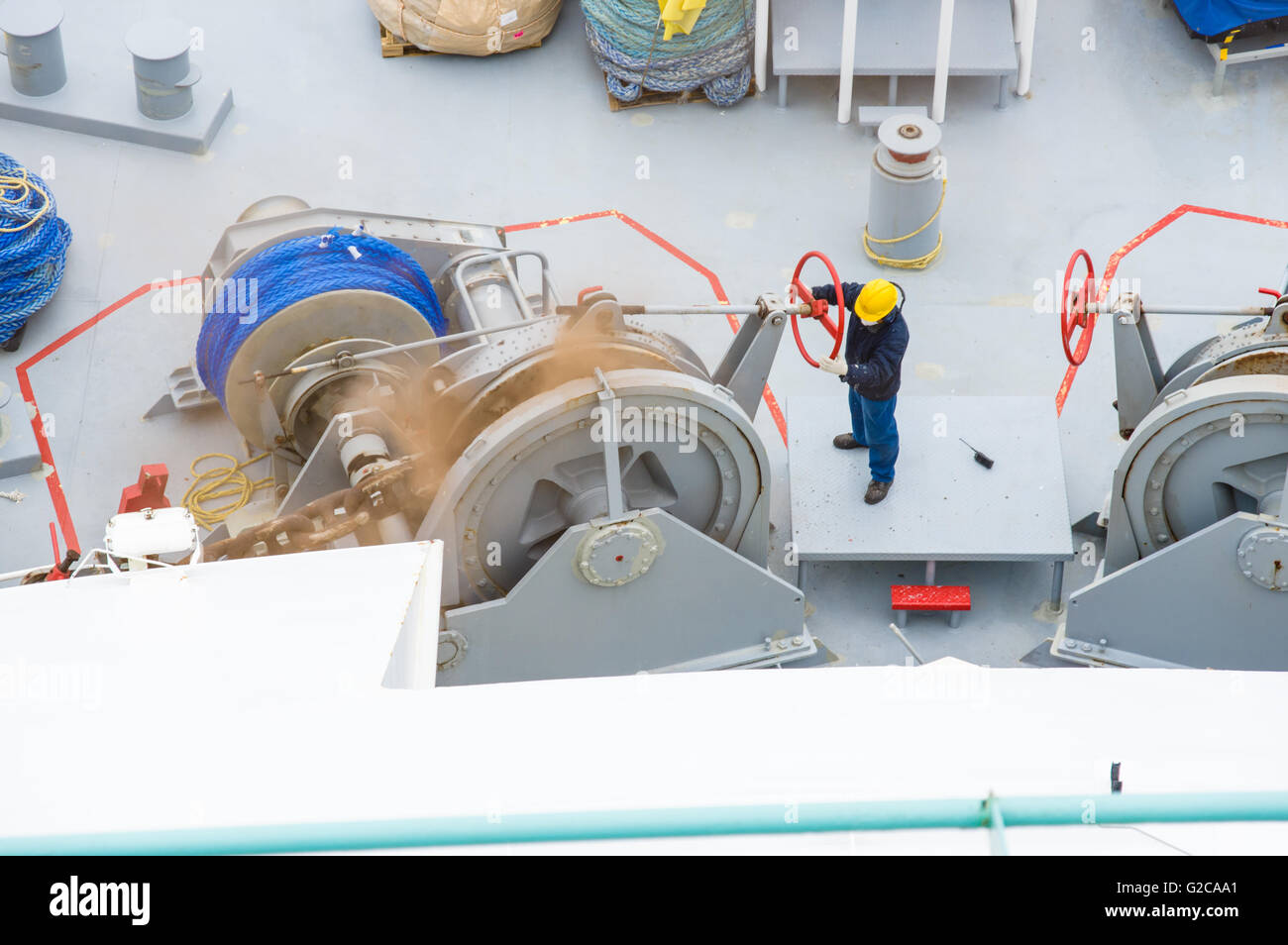 Deck hand prepares to lower the anchor of the Vision of the Seas cruise ...