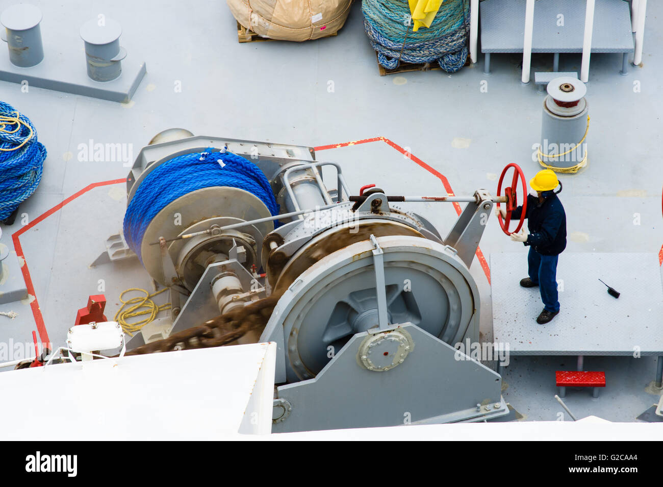 Deck hand prepares to lower the anchor of the Vision of the Seas cruise ...