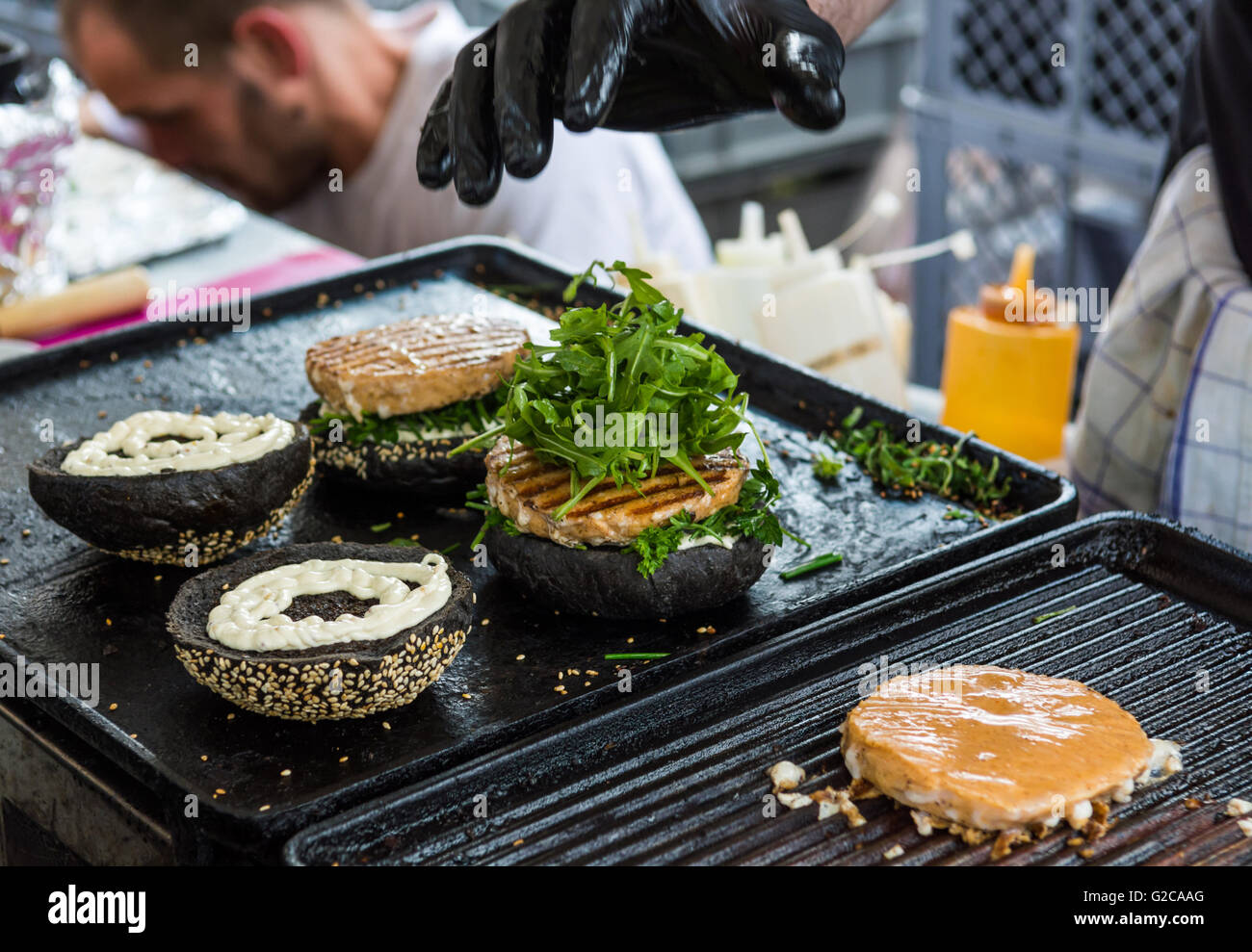 Chef preparing tasty burgers at outdoor stand Stock Photo - Alamy