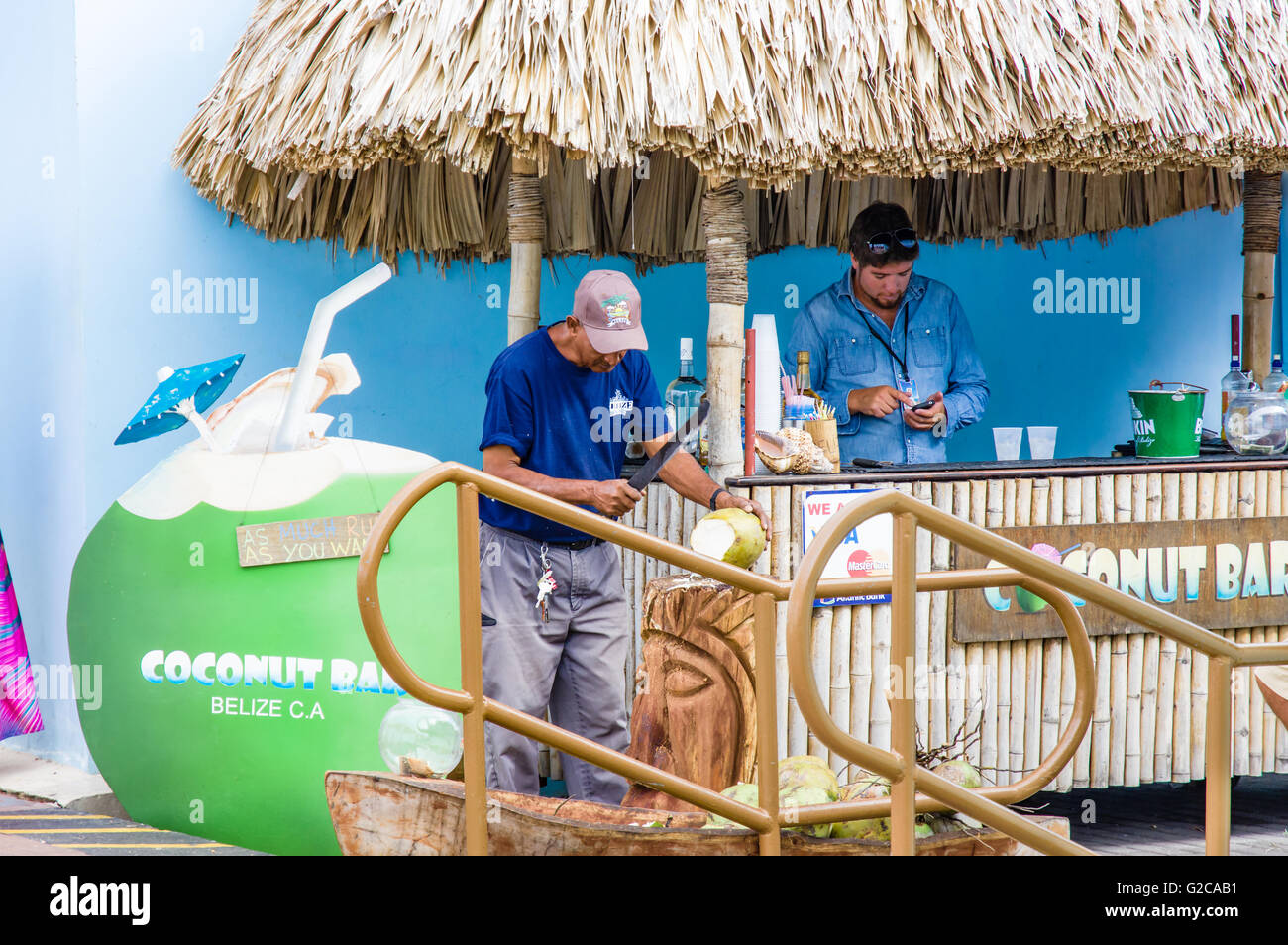 Man chopping coconuts into rum drinks at the Coconut Bar in Belize City ...