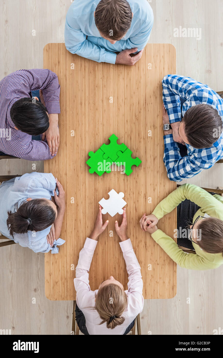 People assembling puzzle, corporate teamwork concept Stock Photo - Alamy