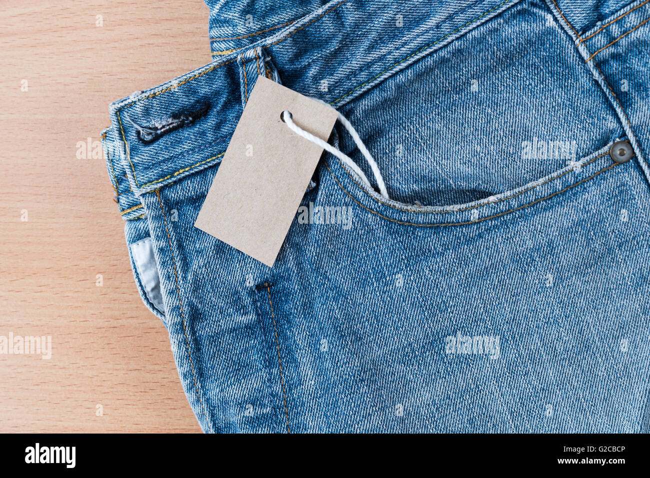 blue jean with price tag on wood background Stock Photo - Alamy