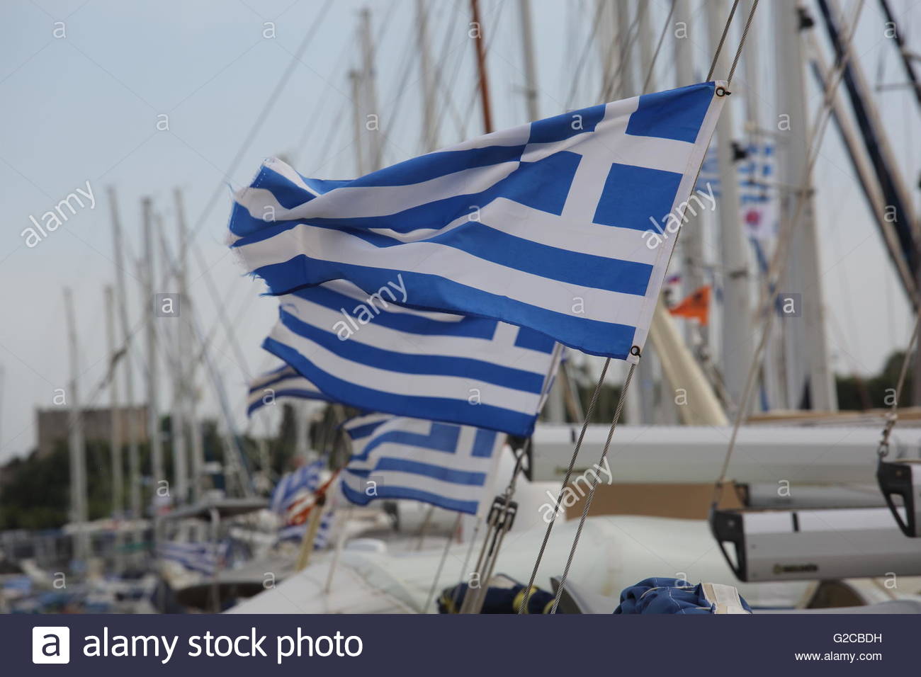 Greek flags blowing in the breeze at a harbour on the island of Rhodes ...