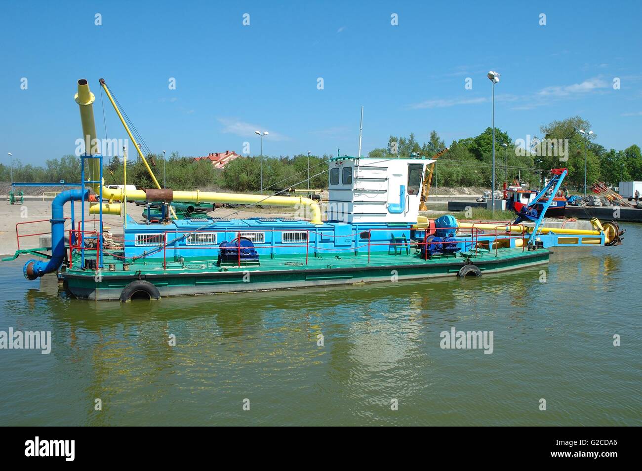 Small dredger vessel in small harbour Stock Photo - Alamy