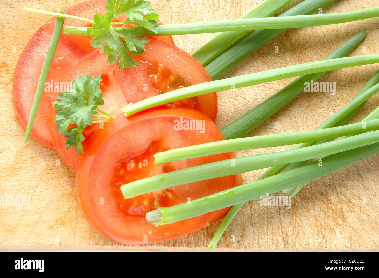 Vegetables on brown chopping board Stock Photo - Alamy
