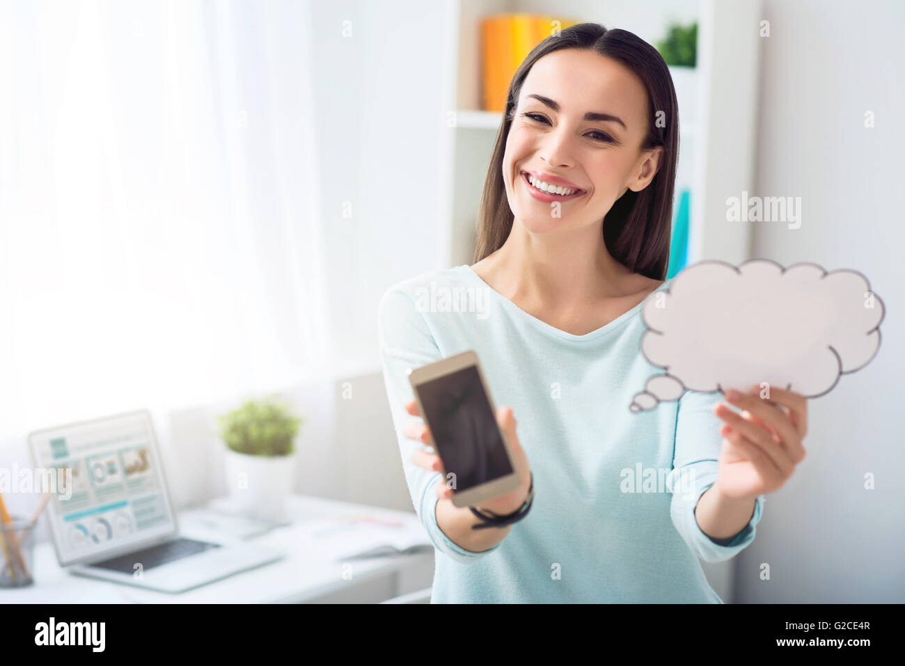 Positive woman holding cell phone Stock Photo - Alamy
