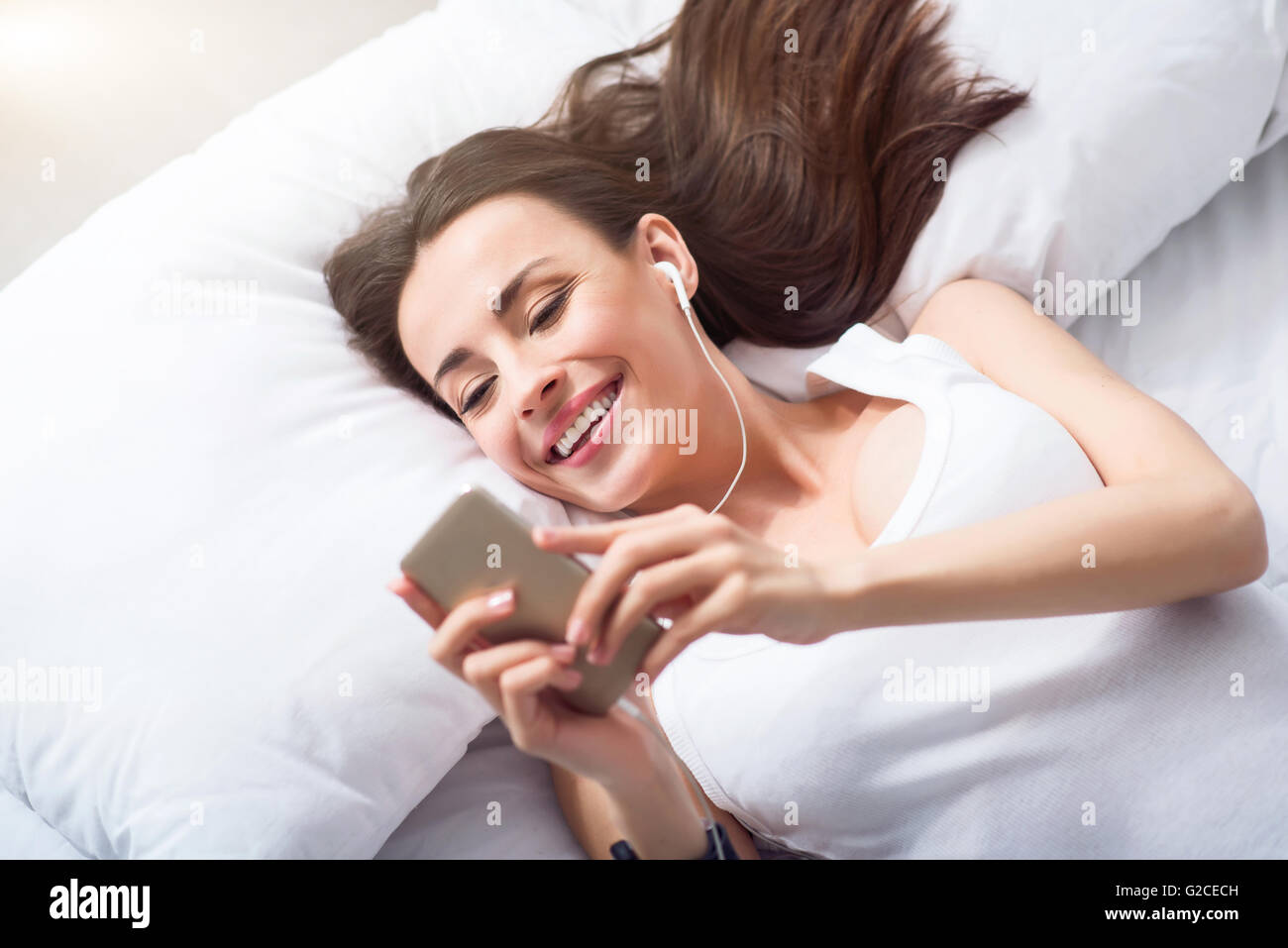 Cheerful beautiful woman resting in bed Stock Photo - Alamy