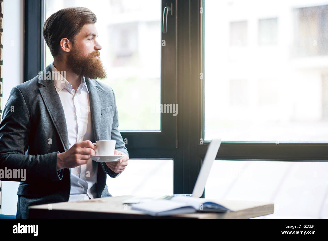 Pleasant bearded man drinking coffee Stock Photo - Alamy