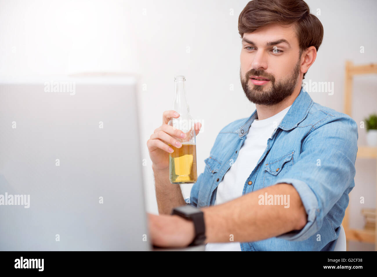 Man working on laptop and drinking beverage Stock Photo - Alamy