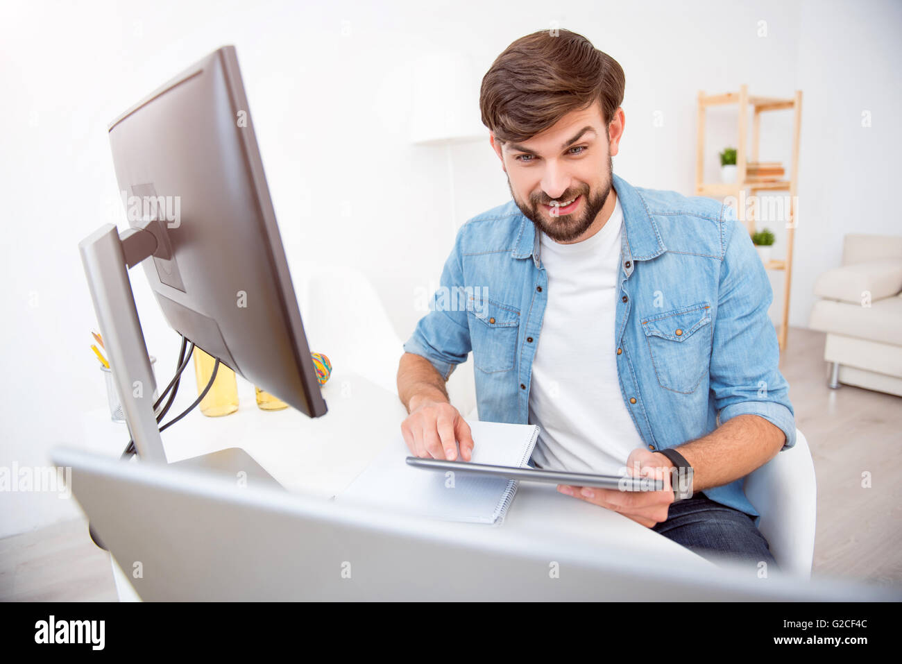 Smiling guy looking at his laptop Stock Photo - Alamy