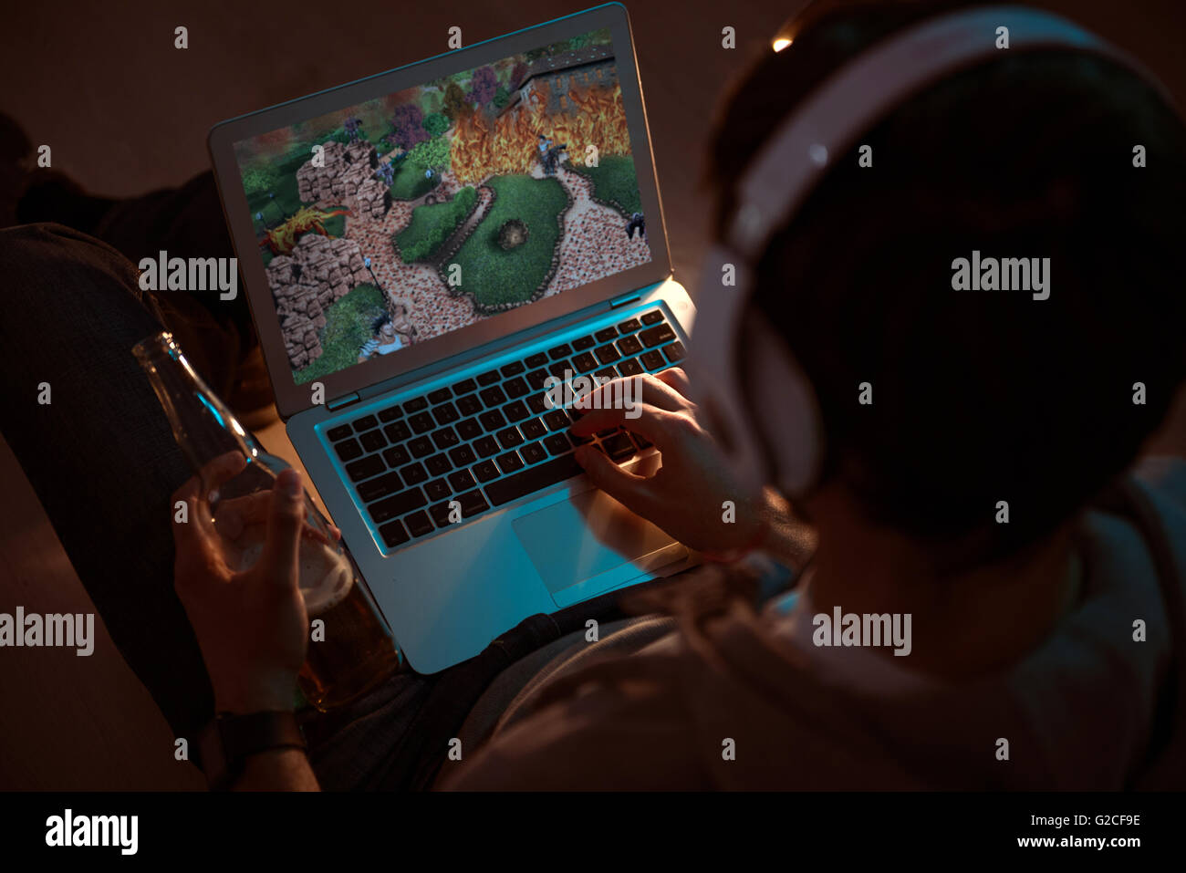Man playing videogame on laptop Stock Photo - Alamy