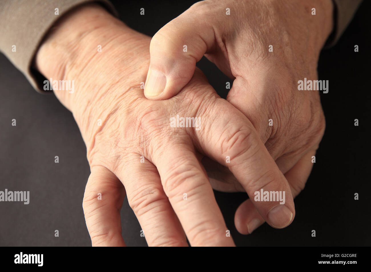 Senior man indicates where he feels pain on the back of his hand Stock ...