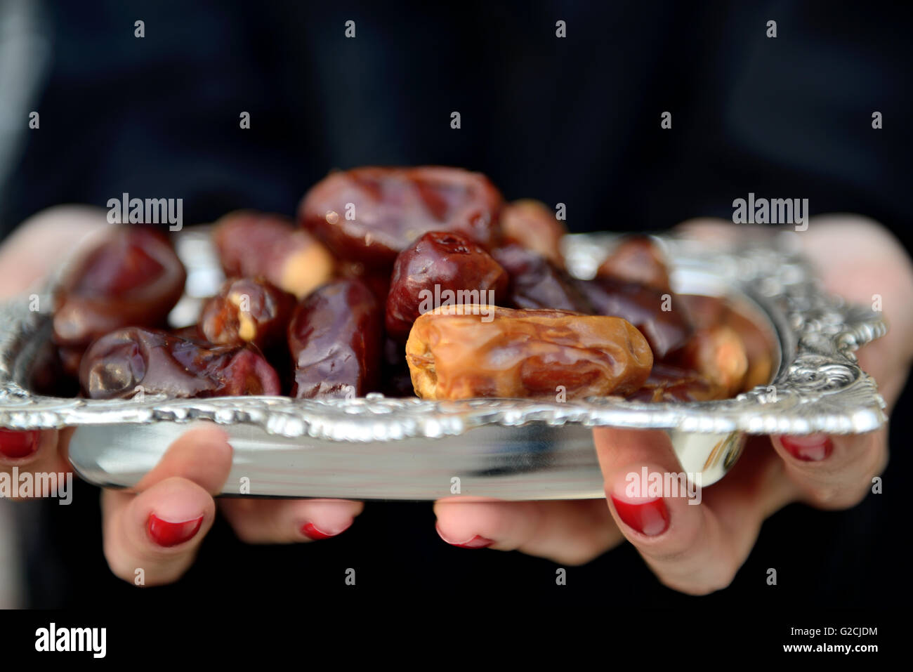 Emarati Arab woman holding dates plate, Dubai, United Arab Emirates ...