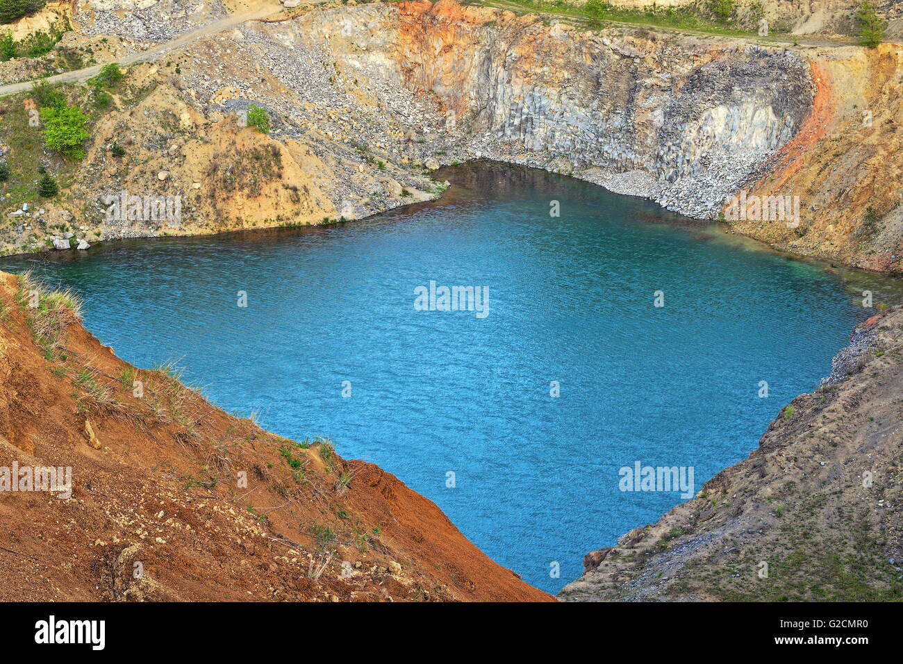 the emerald lake in old abandoned basalt quarry, Racos, Romania Stock ...