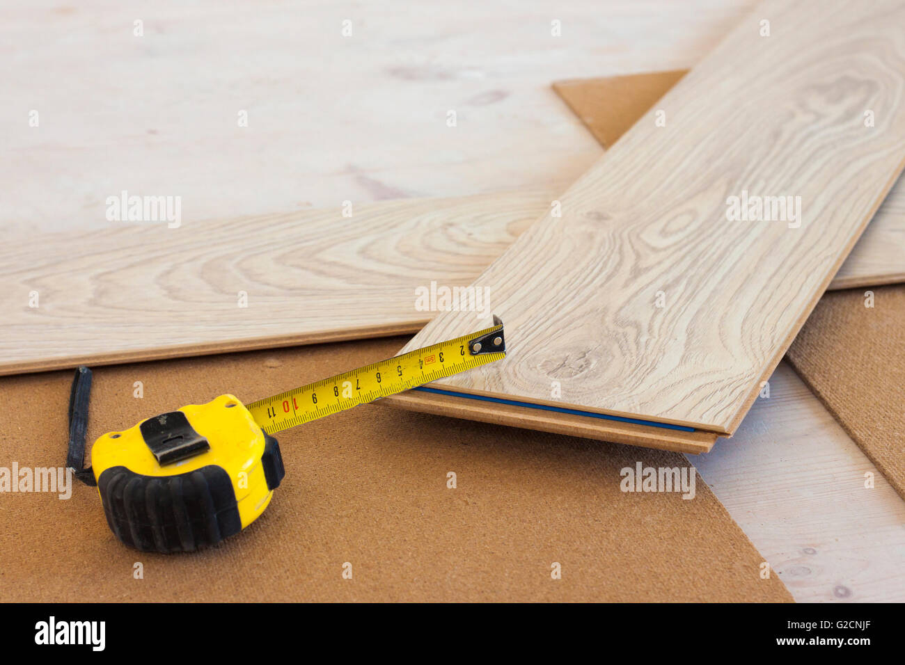 Measuring tape on laminate floor plank Stock Photo - Alamy