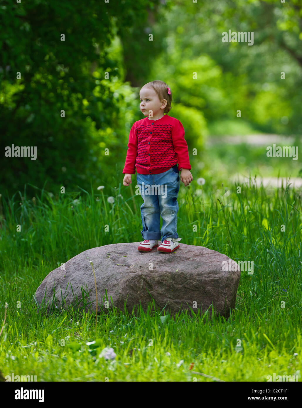 little girl standing on big stone Stock Photo - Alamy