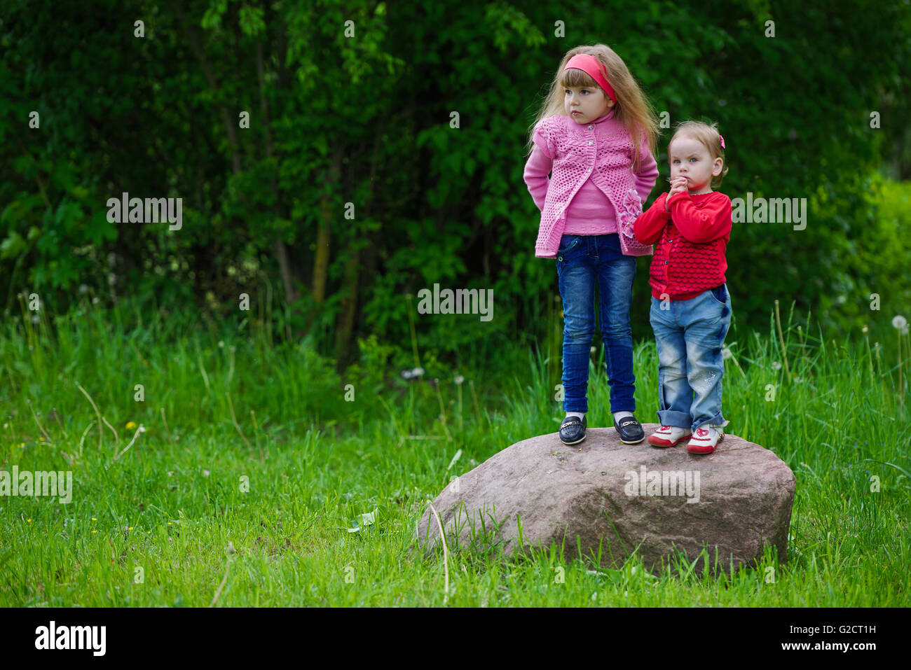 little girls standing on big stone Stock Photo - Alamy