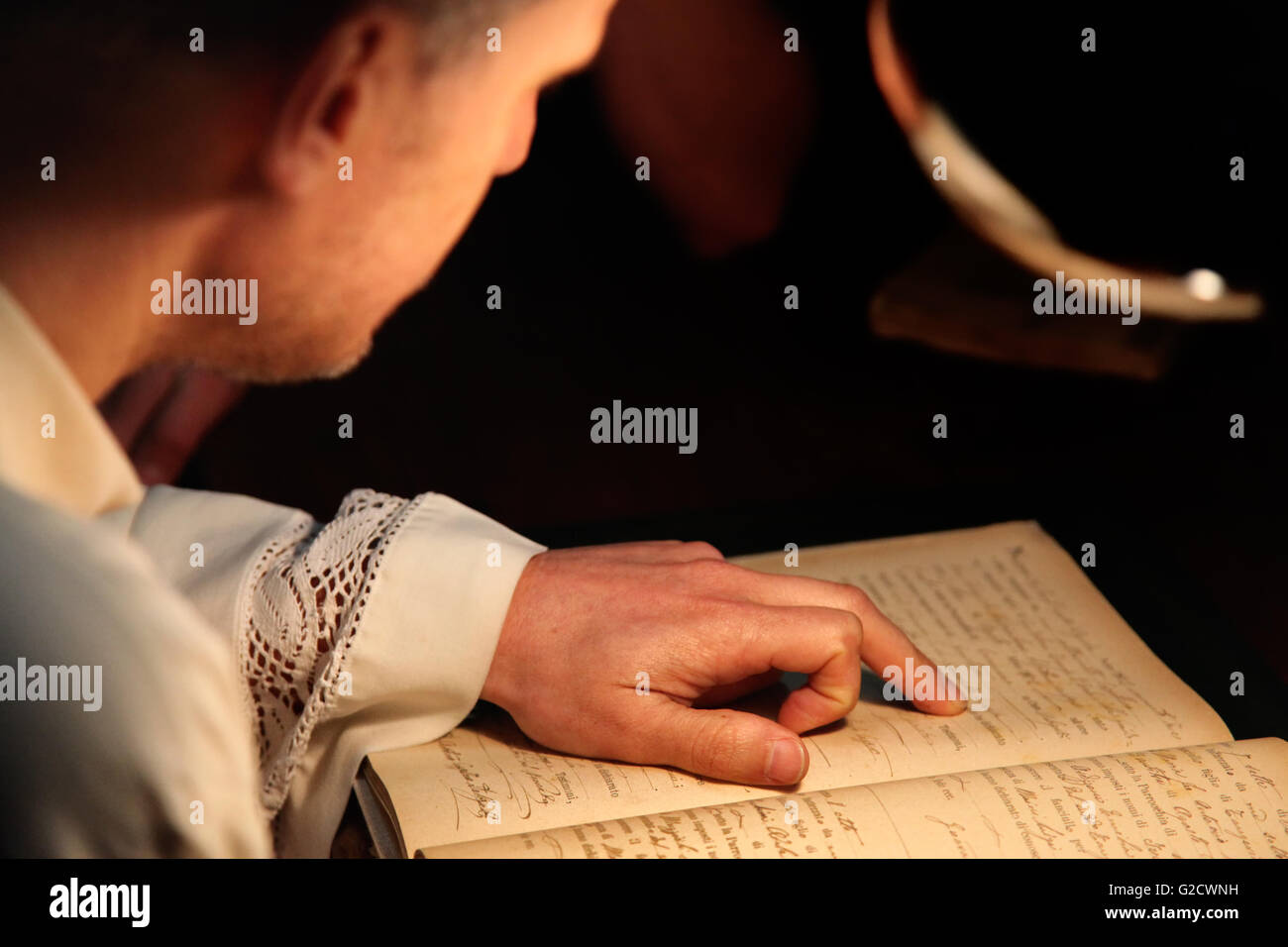 A young priest reading an ancient hand written document Stock Photo - Alamy