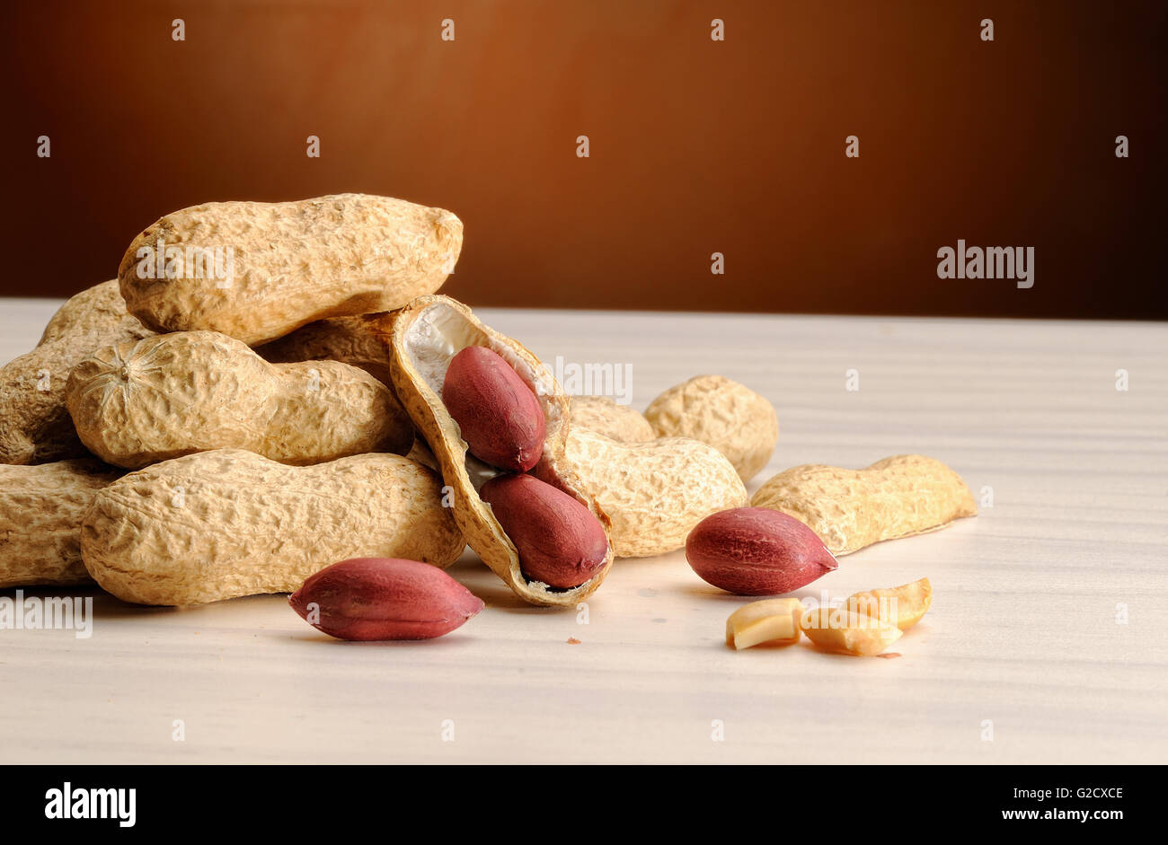 group of peanuts on the white table and brown background Stock Photo ...