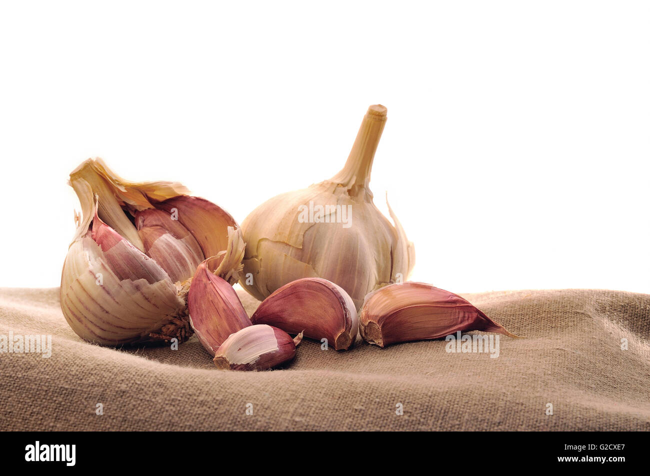 two heads of garlic on brown fabric isolated background Stock Photo - Alamy